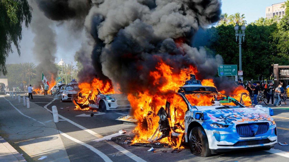 Photos show Waymo vehicles on fire during LA protests as company cuts ...
