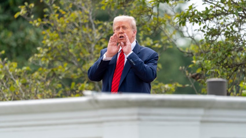 President Donald Trump shouts to reporters as he surveys the grounds from the roof above the Colonnade that goes to the West Wing of the White House, Tuesday, Aug. 5, 2025, in Washington.
